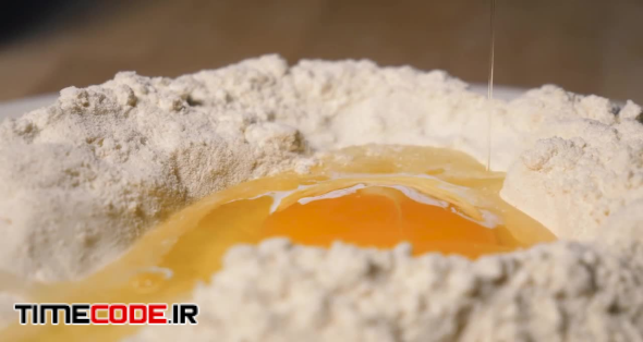 دانلود استوک فوتیج : آرد و تخم مرغ Egg Dropping Into Flour – تایم کد